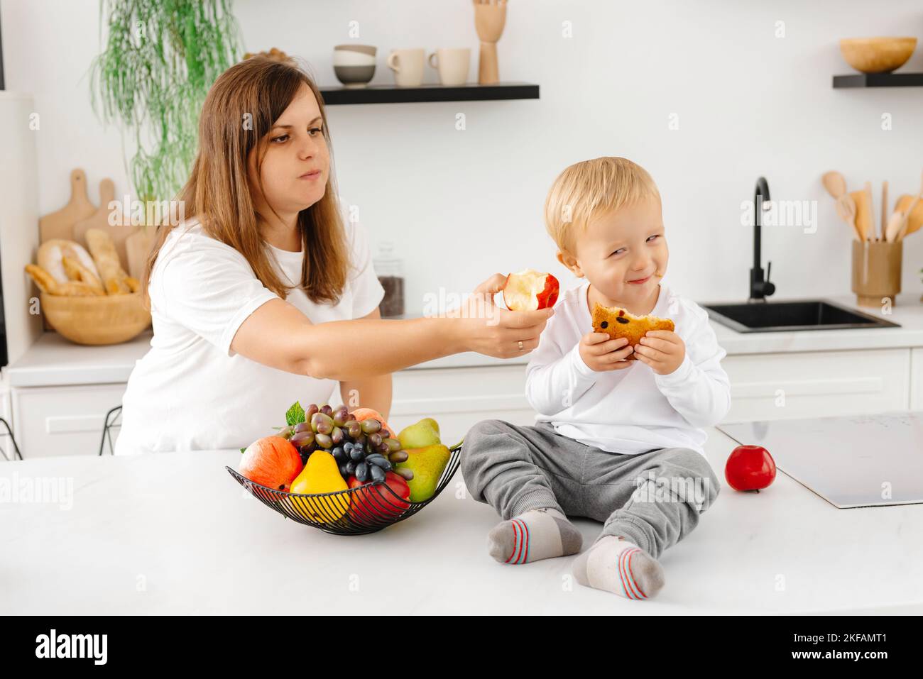 Mom makes the child eat right. Mom is trying to teach her child to eat ...