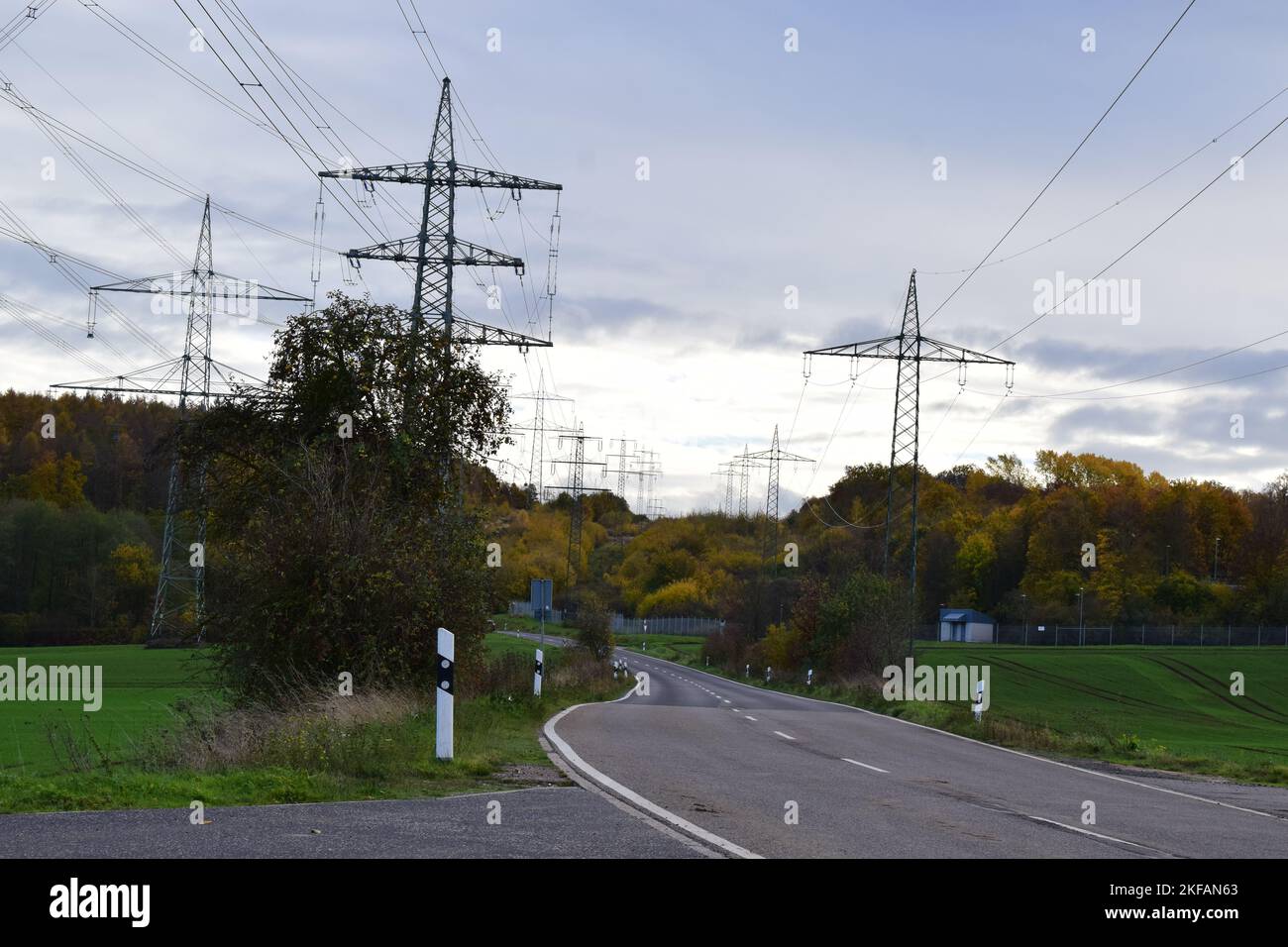 electric grid around a road on a gloomy day Stock Photo - Alamy