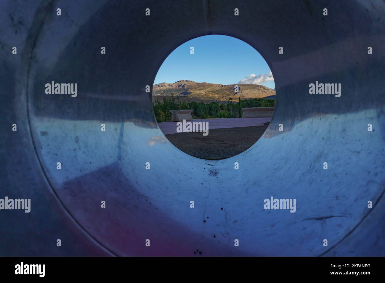 mountain scenery with cloudy sky seen from inside a tunnel in a public ...