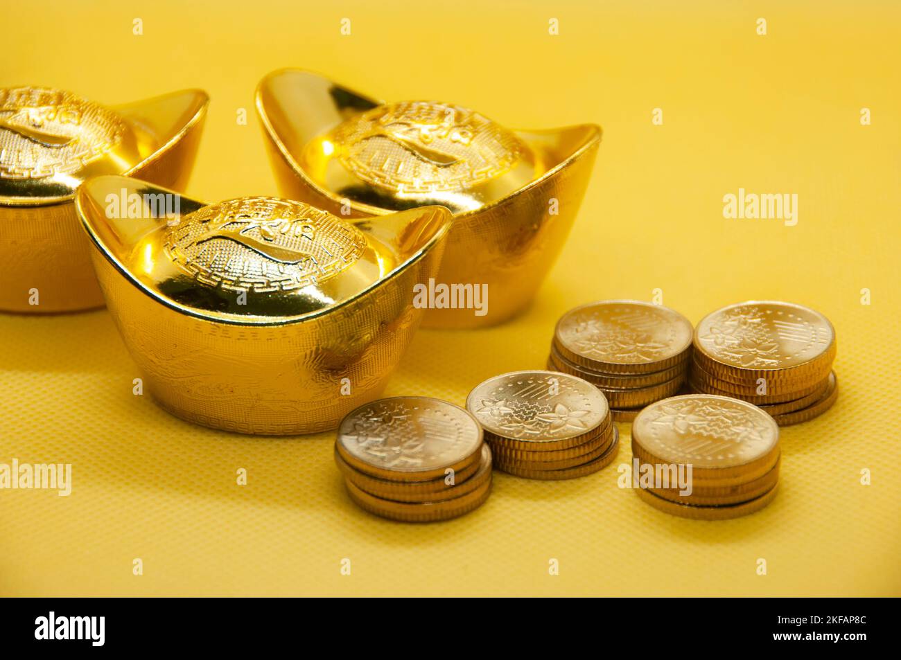 Chinese Gold Ingots and gold coins on yellow background Stock Photo - Alamy