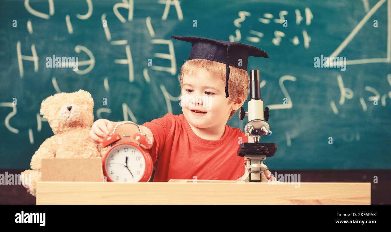 School break concept. Child on smiling face looks at alarm clock. Pupil ...