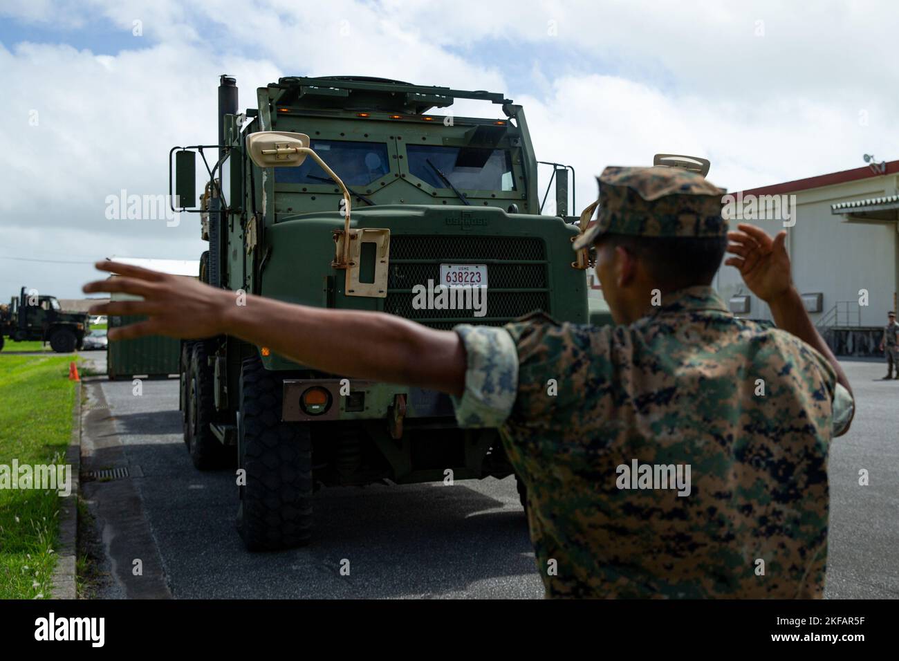 A U.S. Marine ground guides a Medium Tactical Vehicle Replacement with ...