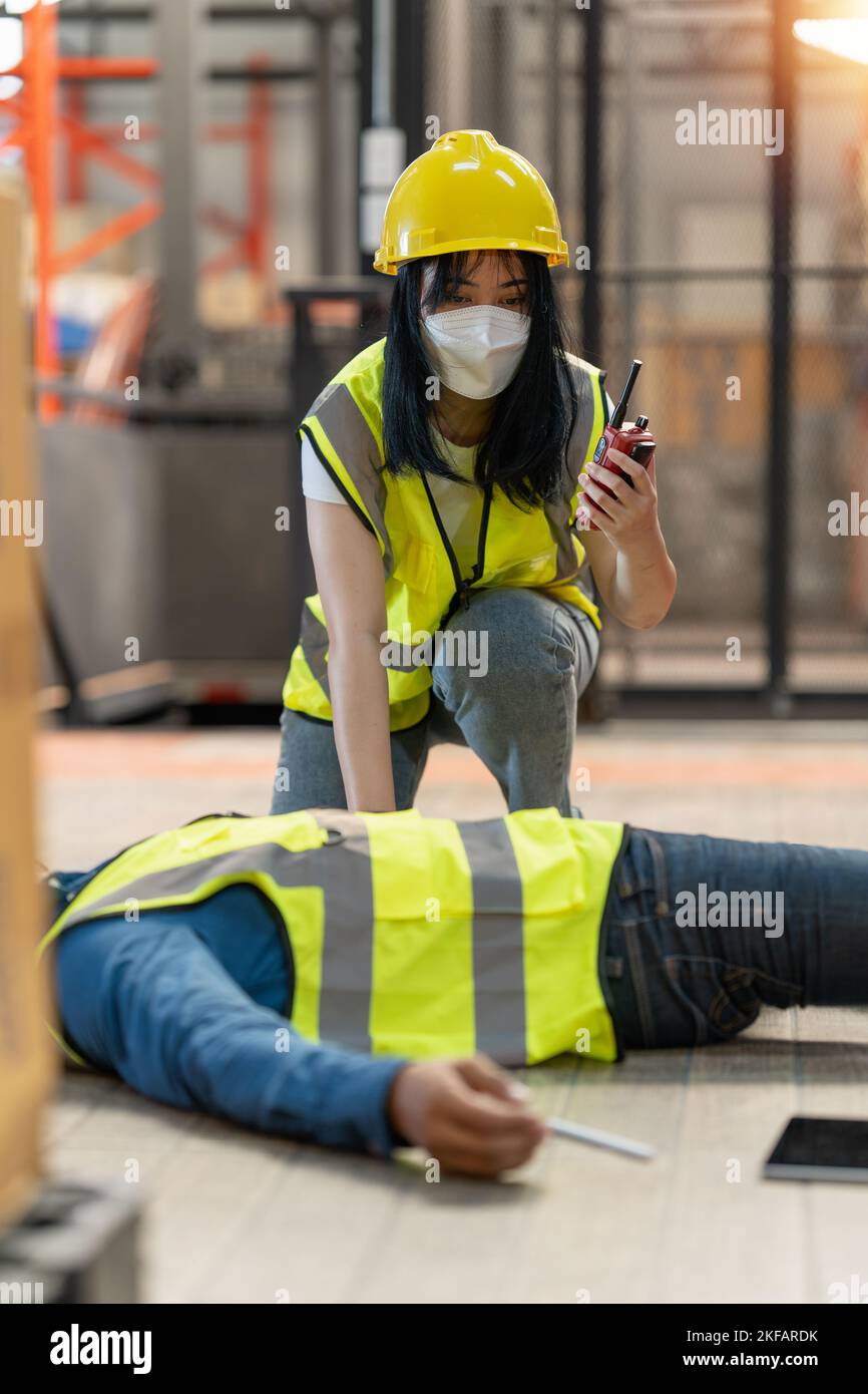 First aid by workmate. Working at warehouse. Male warehouse worker have ...