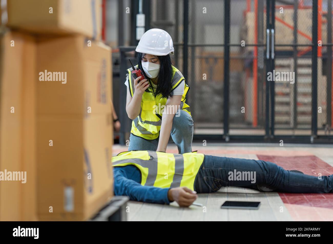 First aid by workmate. Working at warehouse. Male warehouse worker have ...