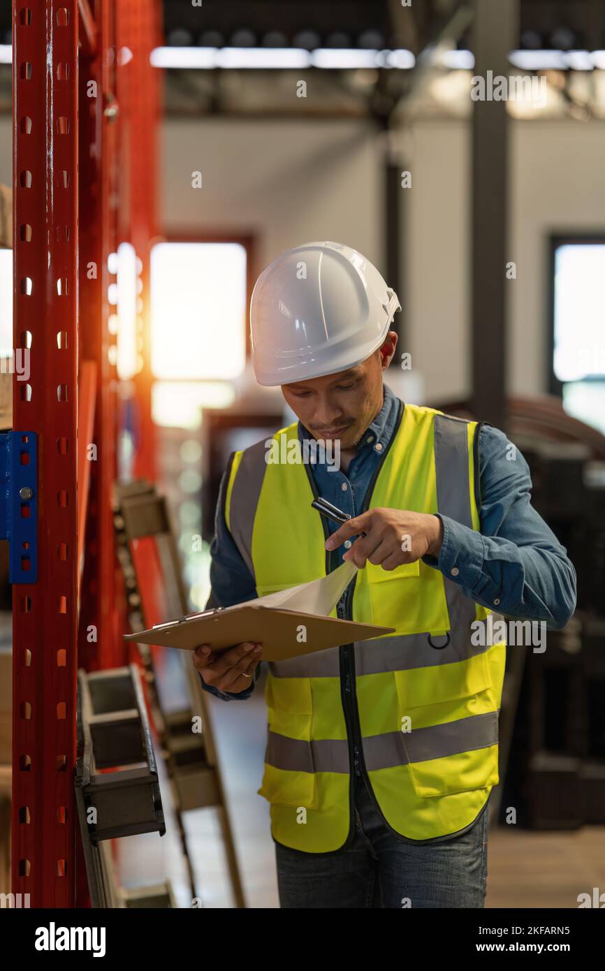 Working at warehouse. Male warehouse worker checking in storage ...