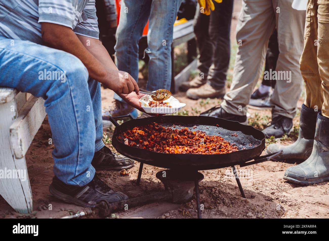 An old man distributing the traditional food on the open fire Stock ...