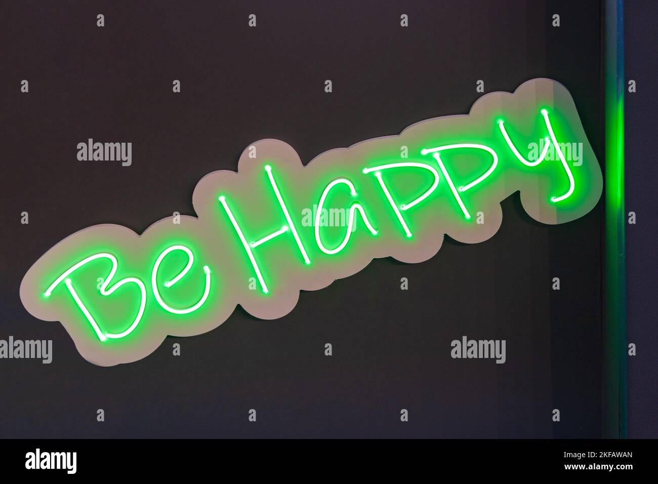 Green Neon Sign Be Happy at Black Wall Stock Photo - Alamy