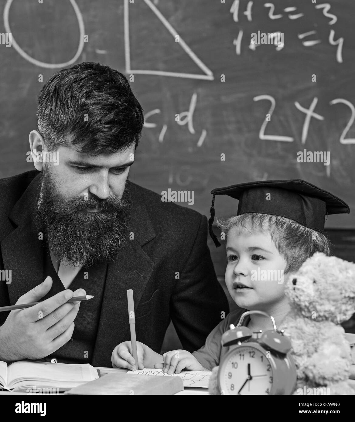 Kid studies with teacher, listening with attention. Elementary education concept. Teacher and ...