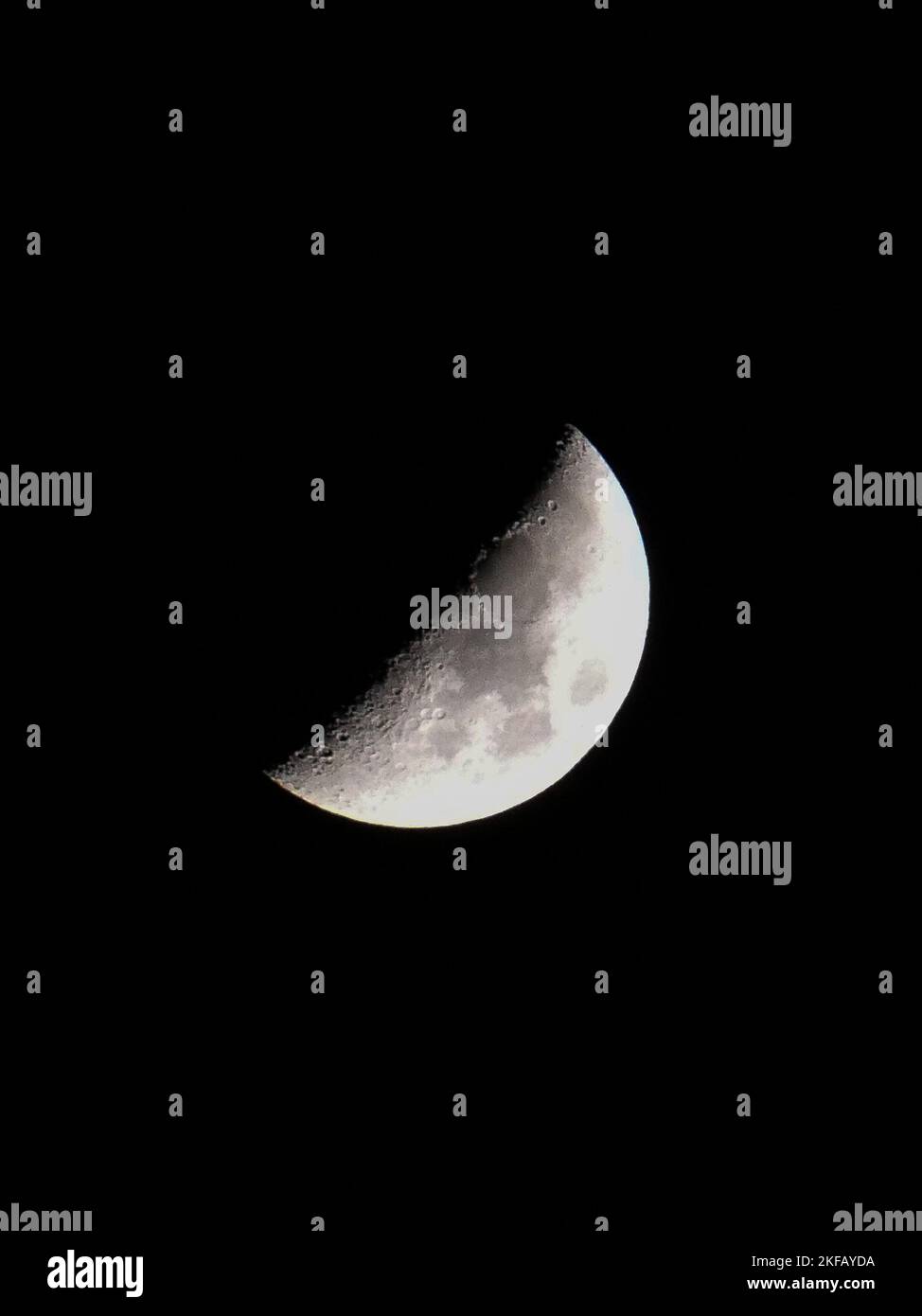 A vertical shot of the half moon in the dark night sky Stock Photo - Alamy