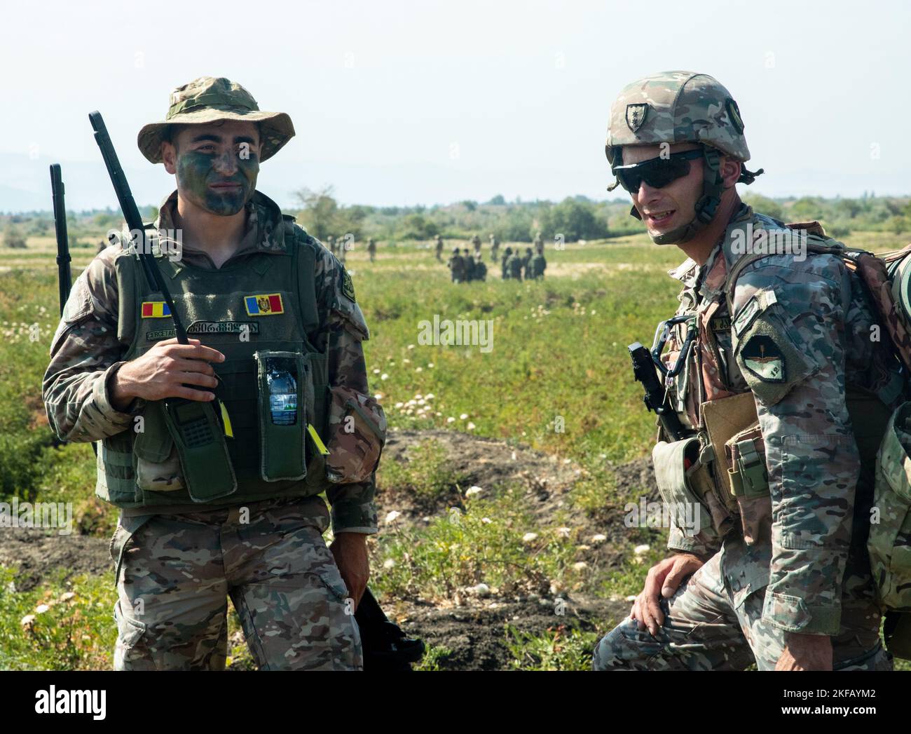A Romanian soldier and Georgian Defense Forces leaders observe their ...