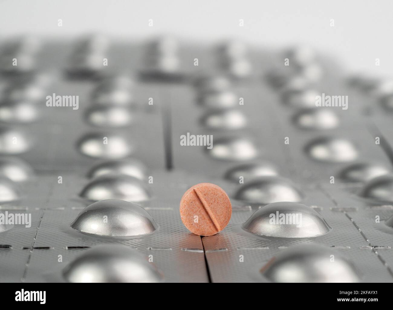Pink pill on the background of packed pills. medicine in tablets. Close ...