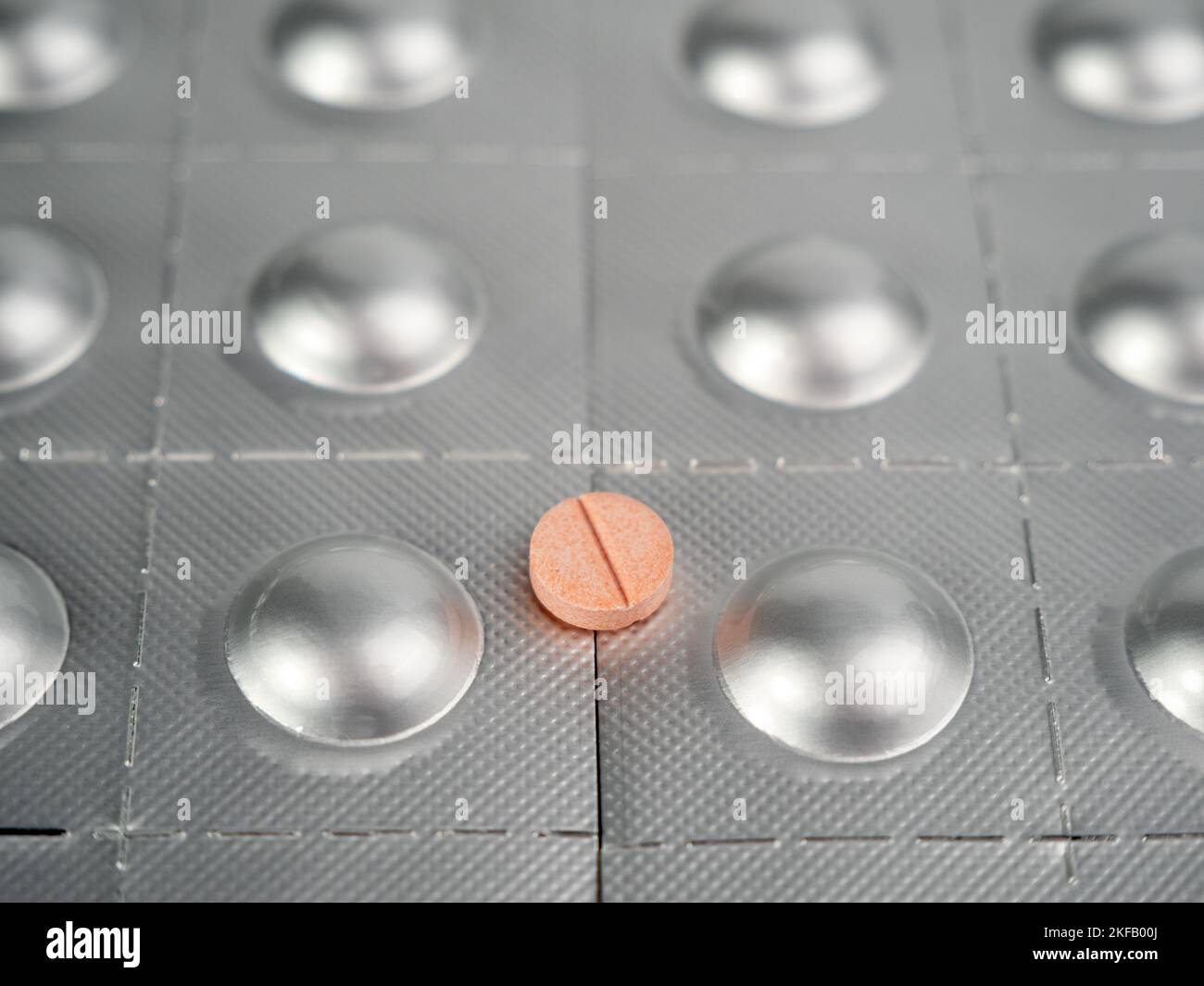 Pink pill on the background of packed pills. medicine in tablets. Close ...