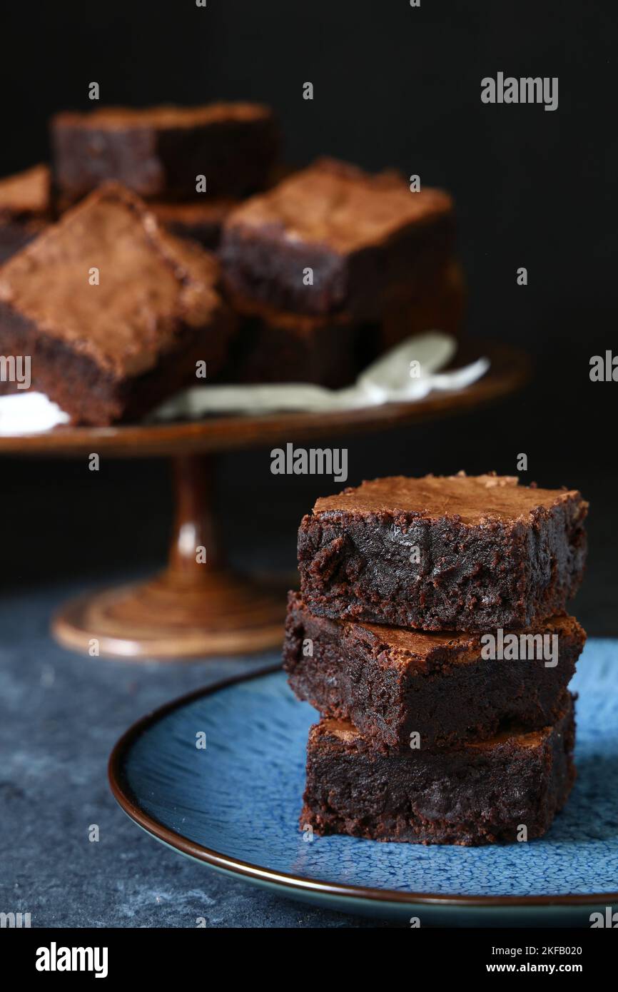 A stack of home baked rich indulgent chocolate brownies on a gold ...