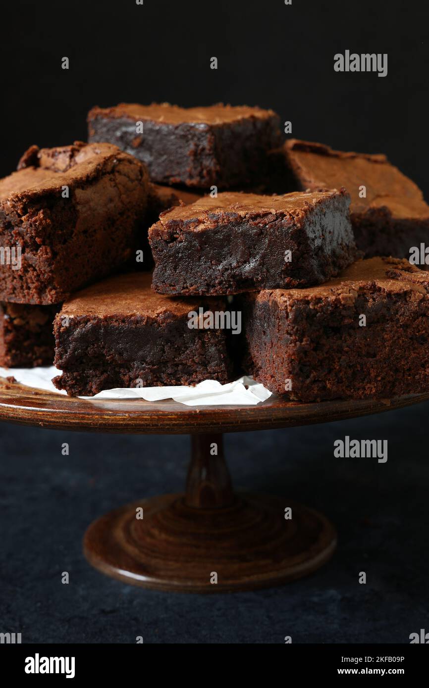 A stack of home baked rich indulgent chocolate brownies on a vintage ...