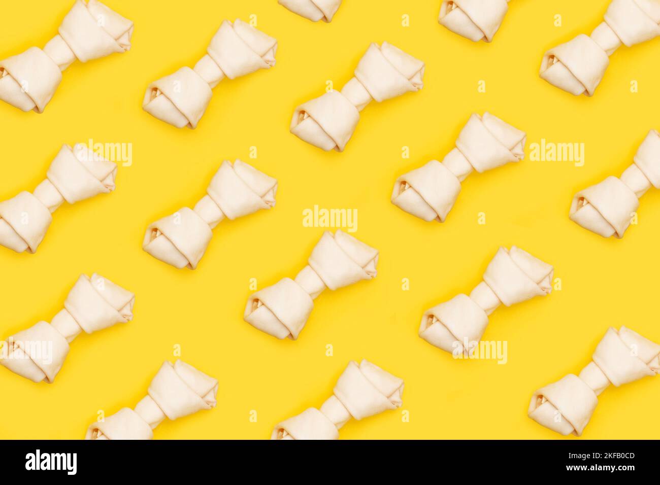 Wallpaper with rawhide bones on a yellow background Stock Photo - Alamy
