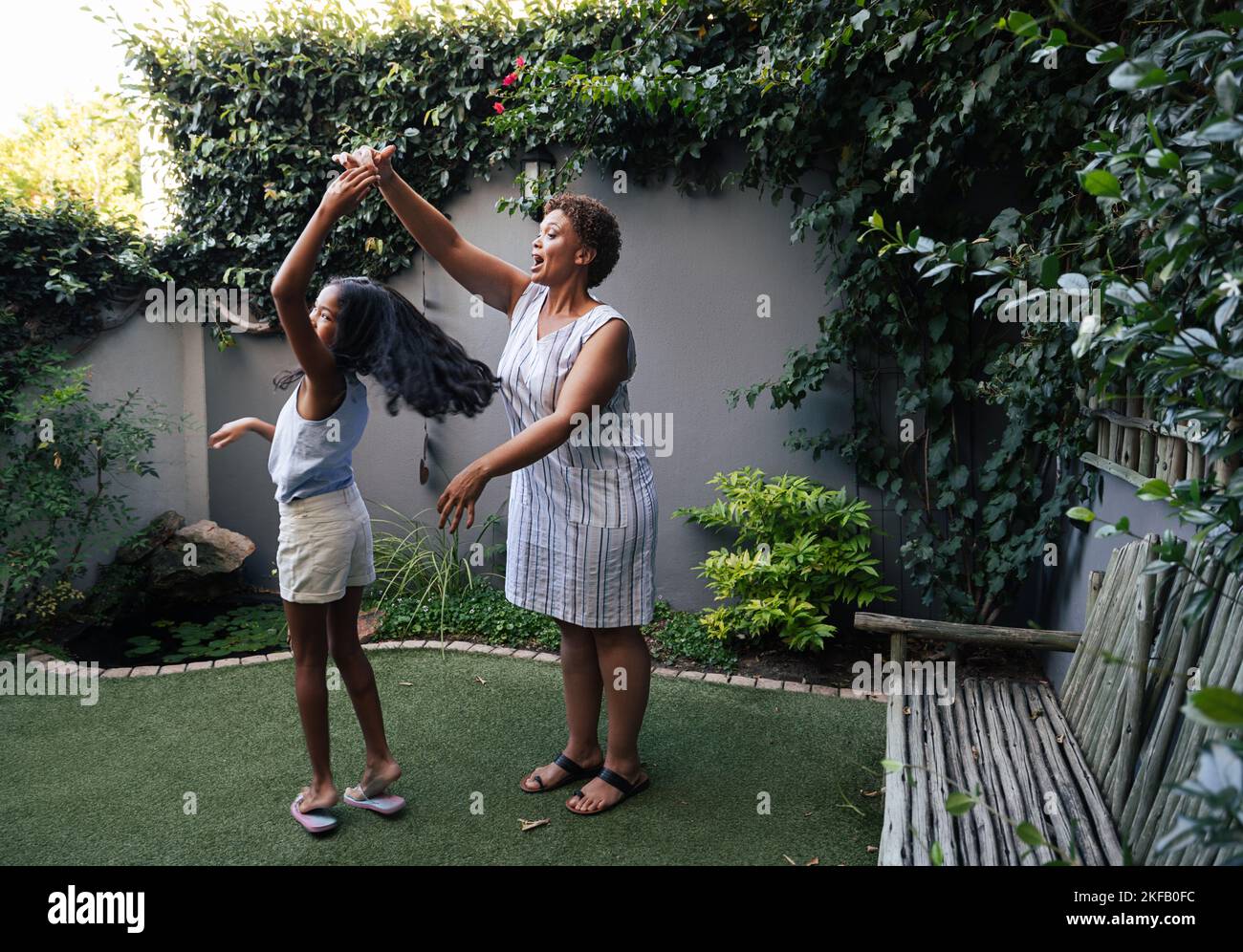 Grandma and girl dancing in the backyard. Mature woman with her ...