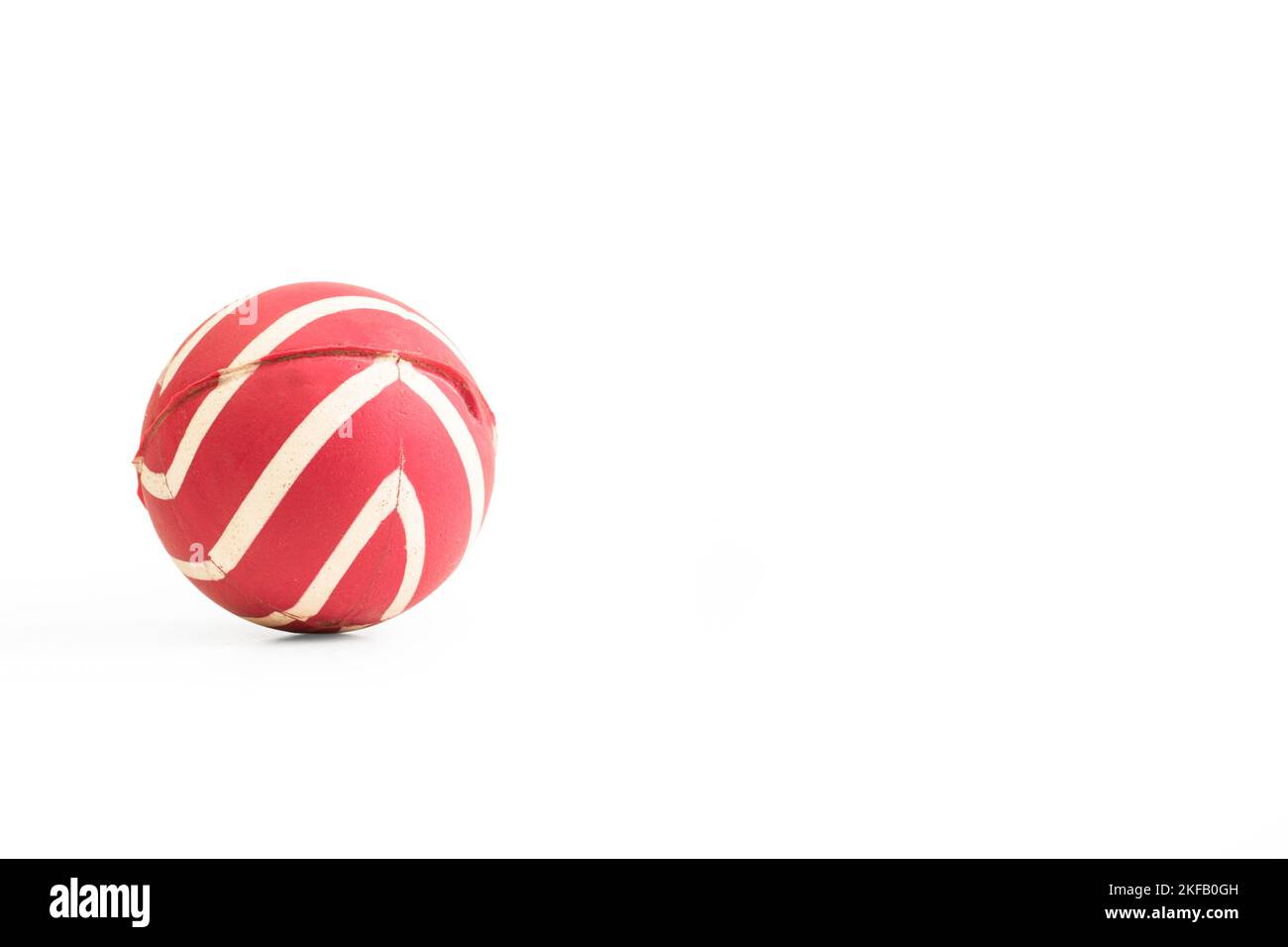 Striped red and white rubber ball isolated on a white background with ...