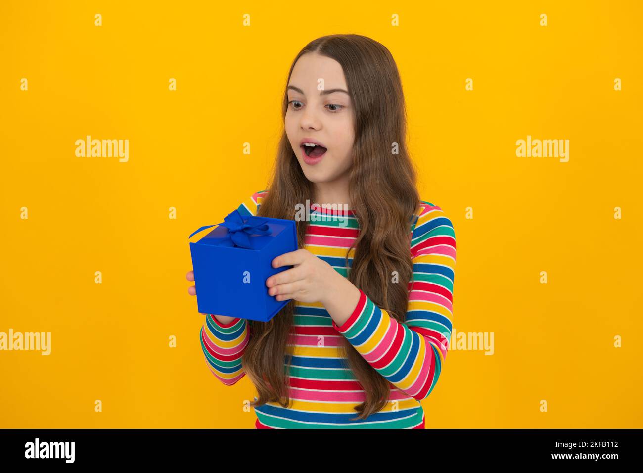Child with gift present box on isolated studio background. Gifting for ...