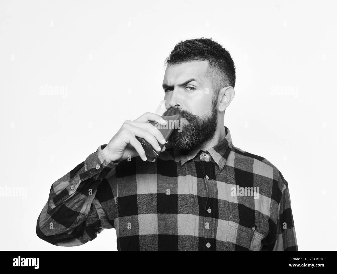 Farmer with strict face drinks glass of fresh red juice Stock Photo - Alamy