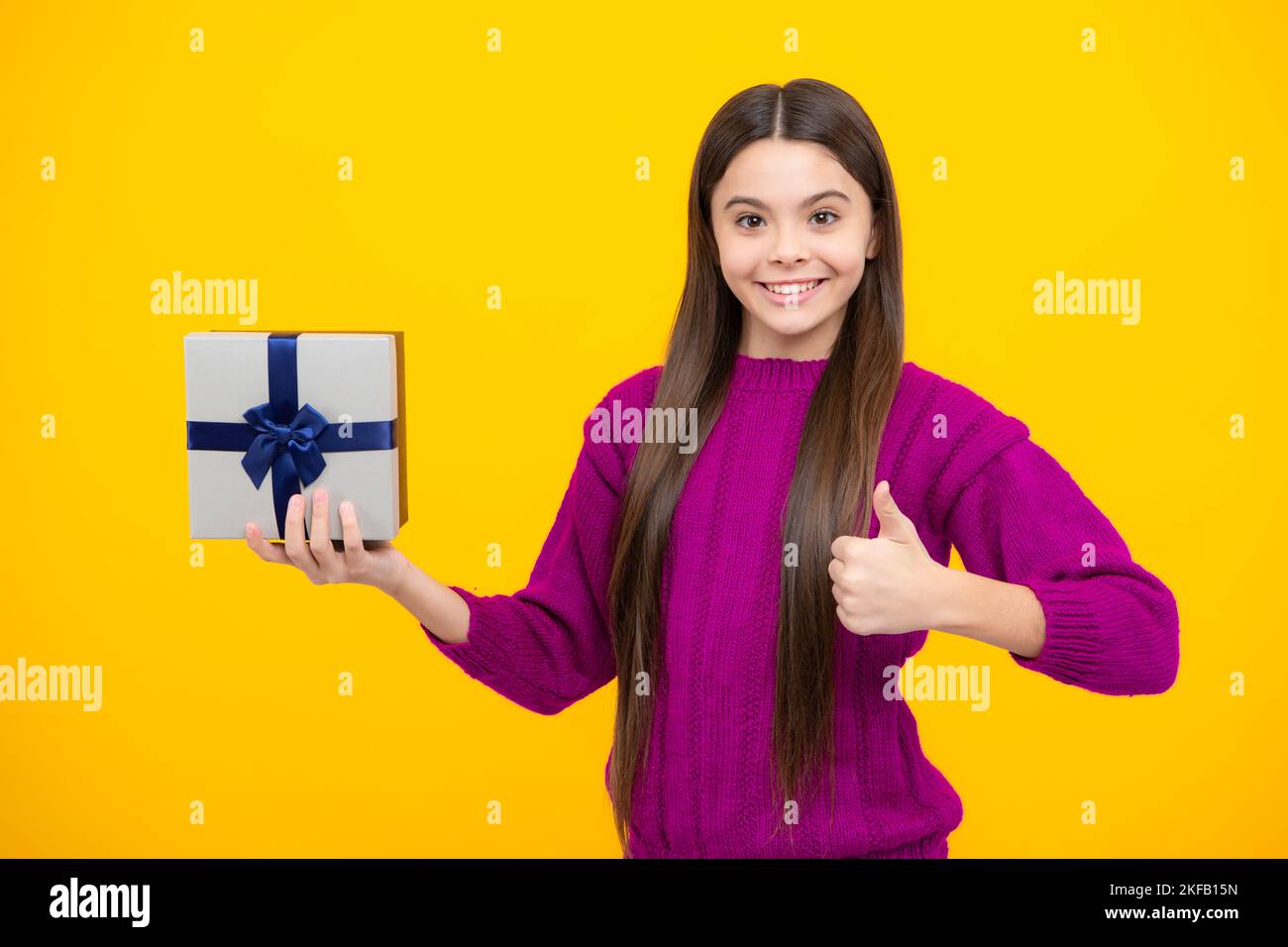Portrait of a teenager child girl holding present box isolated over ...