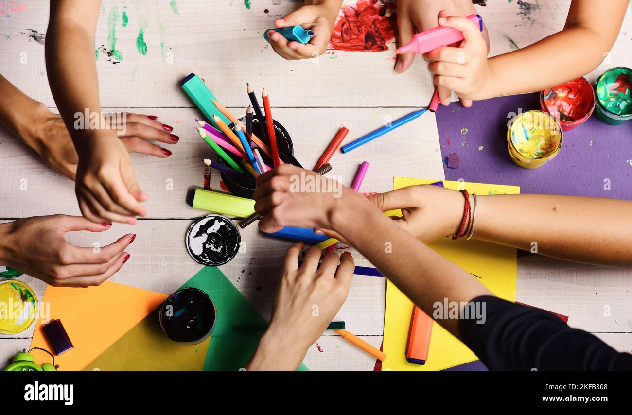 Artists hands with stationery and colored paper. Hands hold markers ...