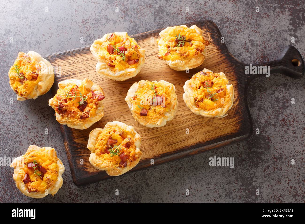 Crispy mini cups of puff pastry stuffed with eggs, cheese and ham close ...