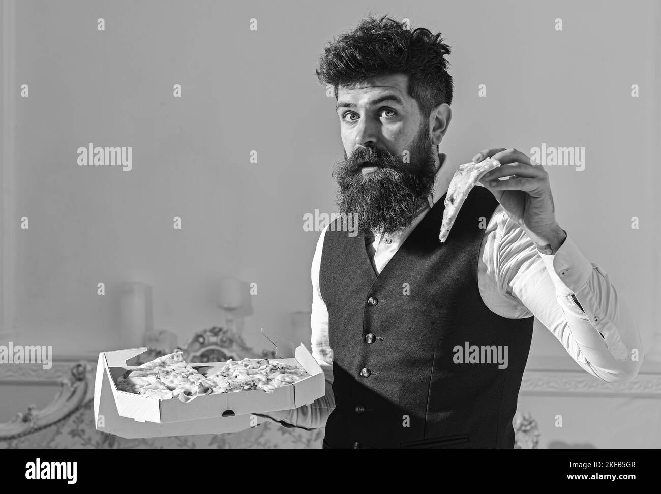 Man with beard and mustache holds box with tasty fresh hot pizza. Macho ...