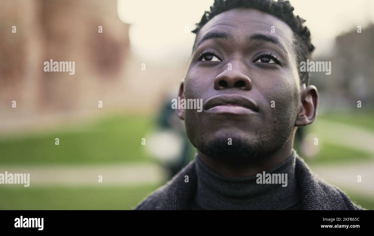 Contemplative young African black man standing looking at sky with HOPE ...