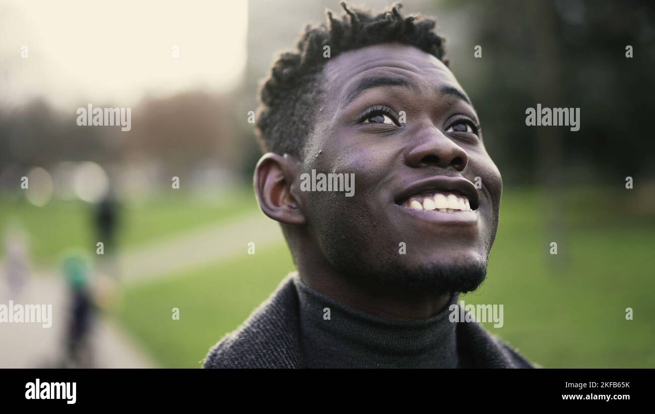 Contemplative young African black man standing looking at sky with HOPE ...