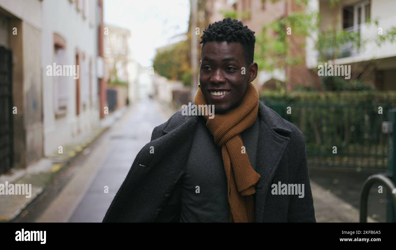 Confident elegant black African walks forward smiling during winter in ...