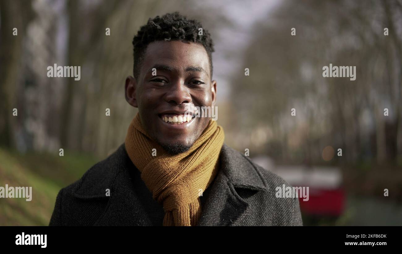 Confident young black African man walking outside in nature park during ...