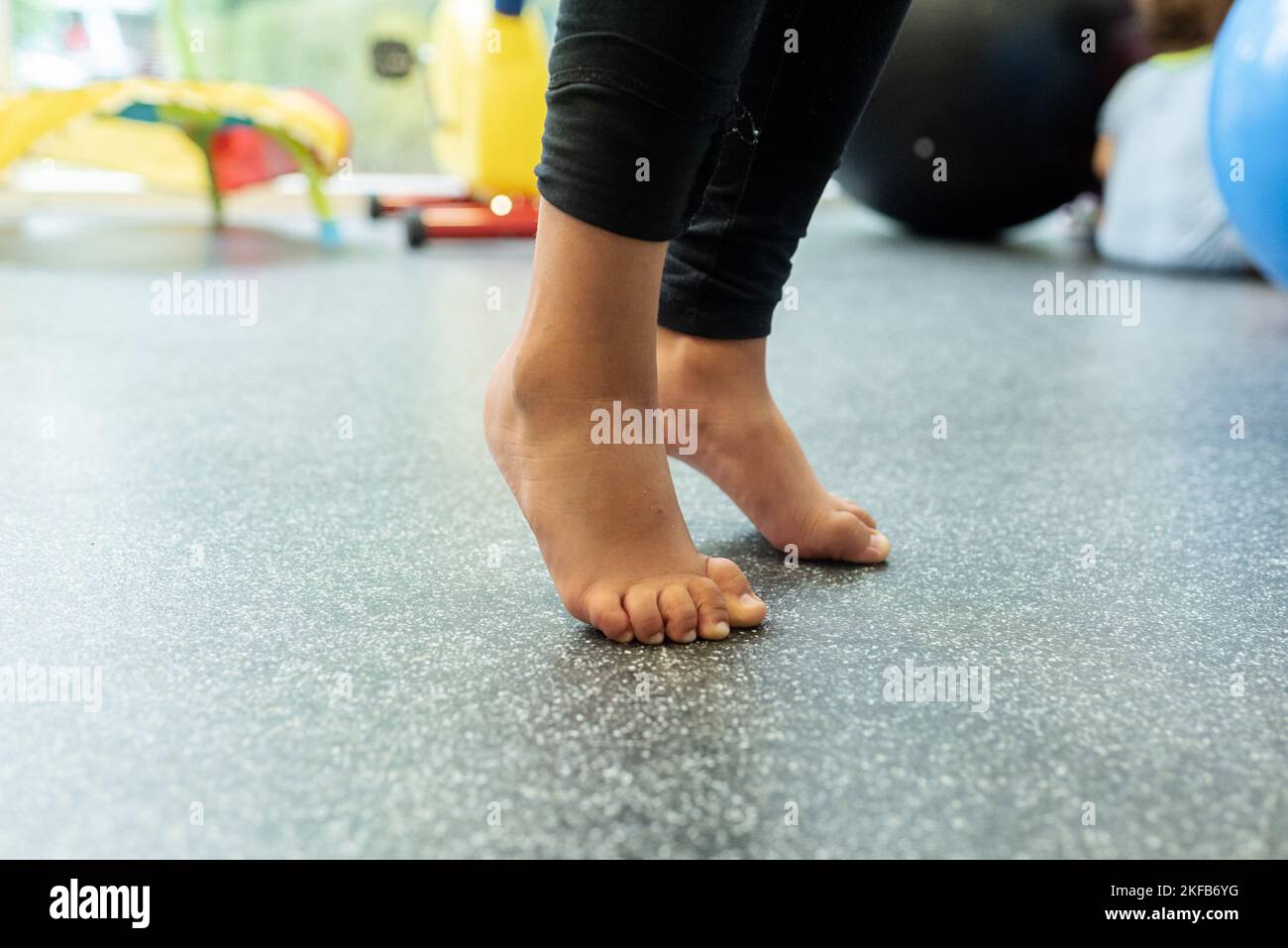 A child with flat feet standing on tiptoes during kinesiotherapy Stock ...