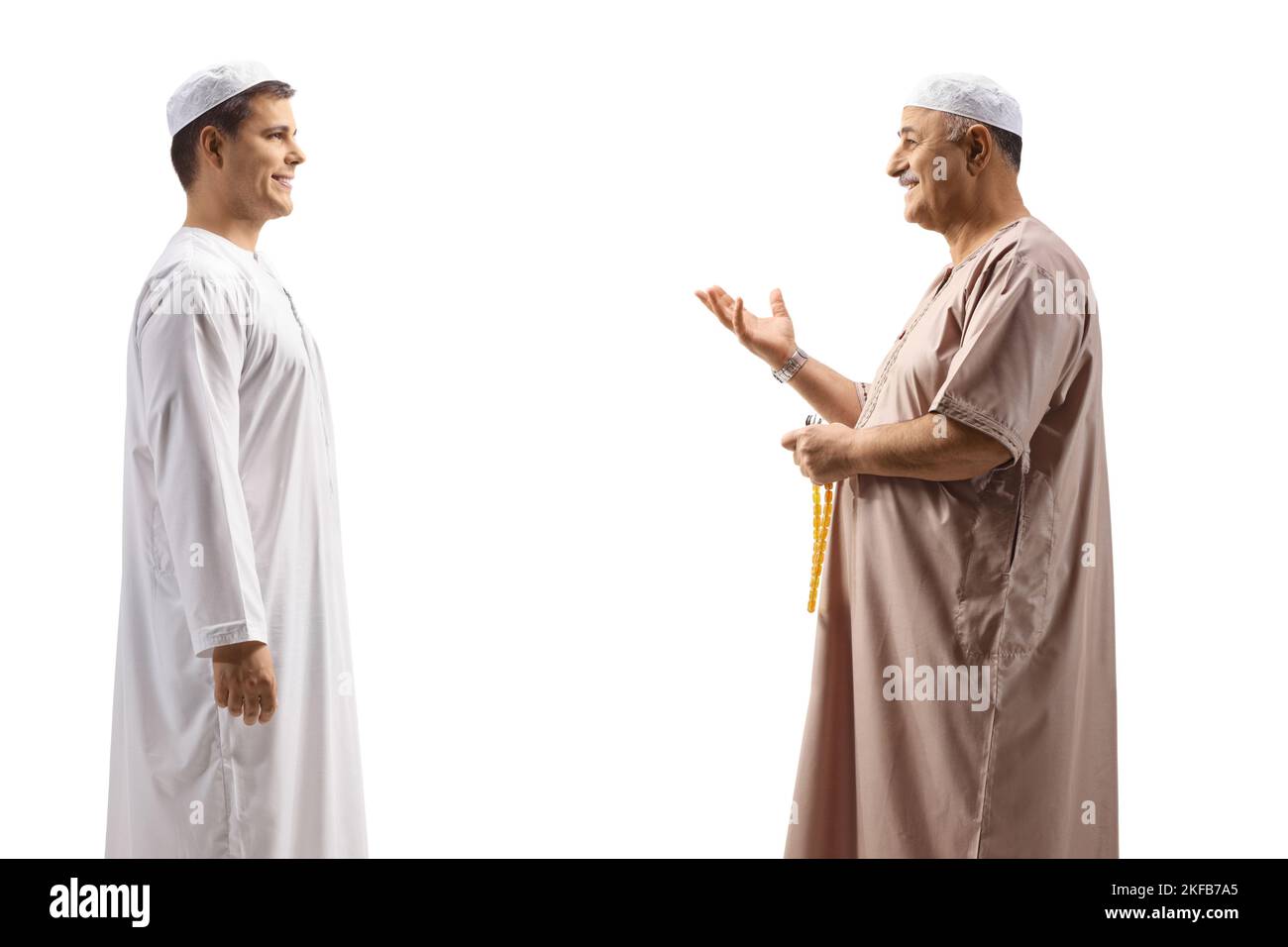 Profile shot of a father and son in islamic ethnic clothes having a ...