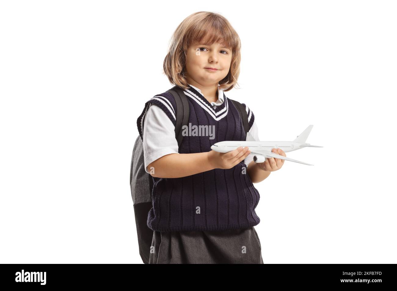 Girl in a school uniform holding an airplane isolated on white ...