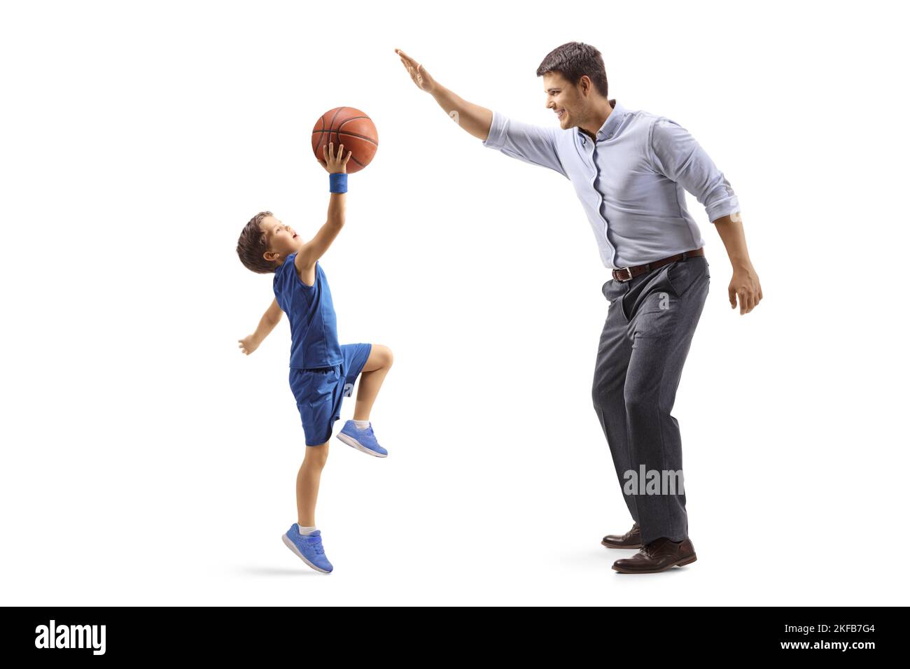 Full length profile shot of a father and son playing basketball ...