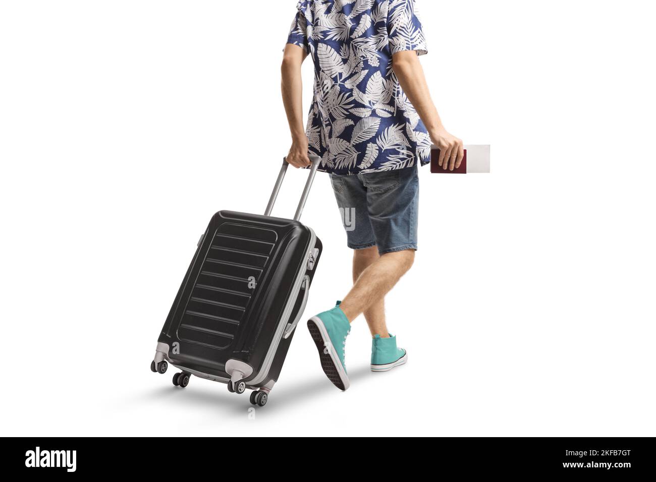 Rear view shot of a male passenger pulling a suitcase and holding a ...