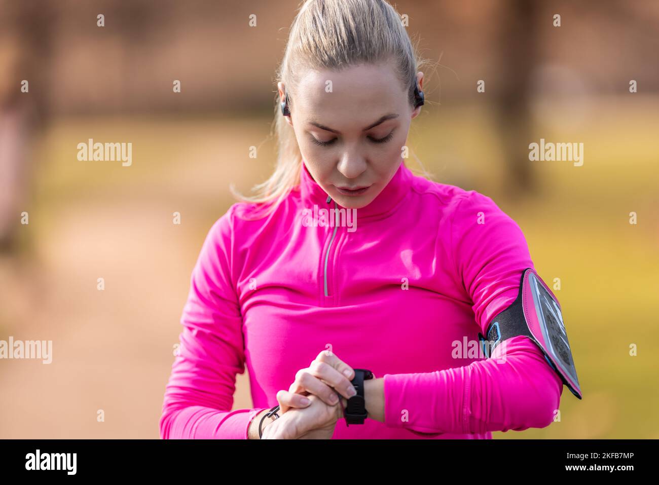A young female runner checks the data on a smart watch after a sports ...