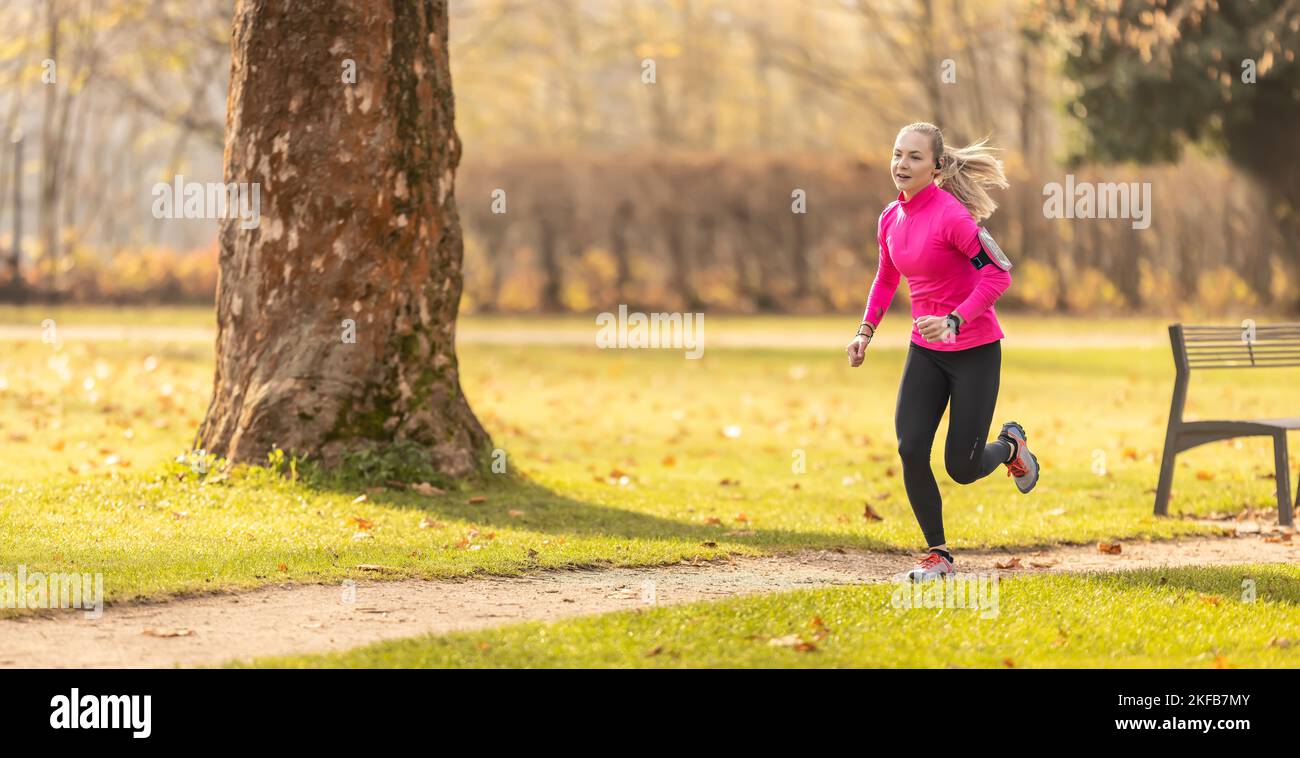 Dynamic running of a young sportswoman in the park Stock Photo - Alamy