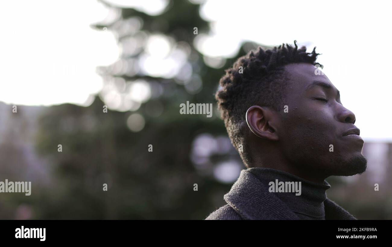 Contemplative young African black man standing looking at sky with HOPE ...
