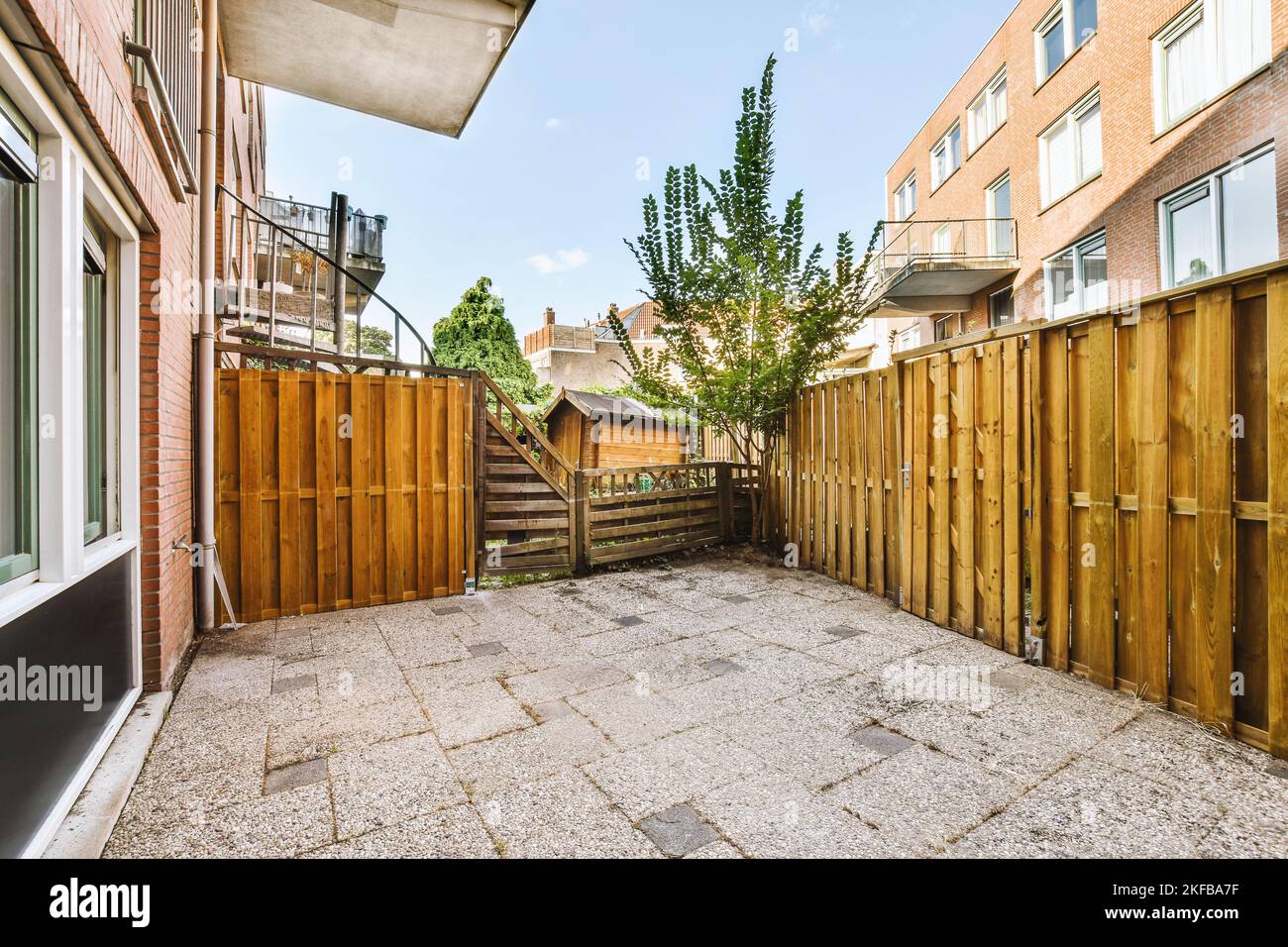 Neat paved patio with wooden fence Stock Photo - Alamy