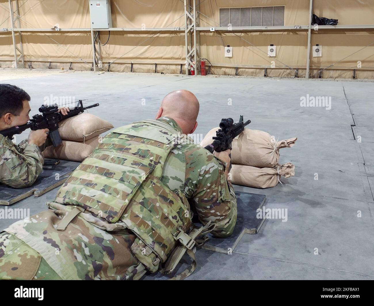U.S. Army Staff Sgt. Jonathan Snelling instructs a Soldier on firing an ...