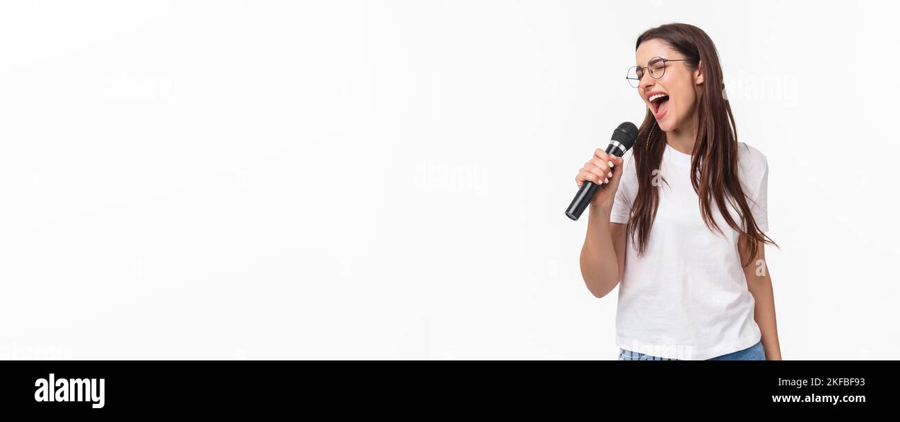 Carefree happy and relaxed young woman singing her heart out ...