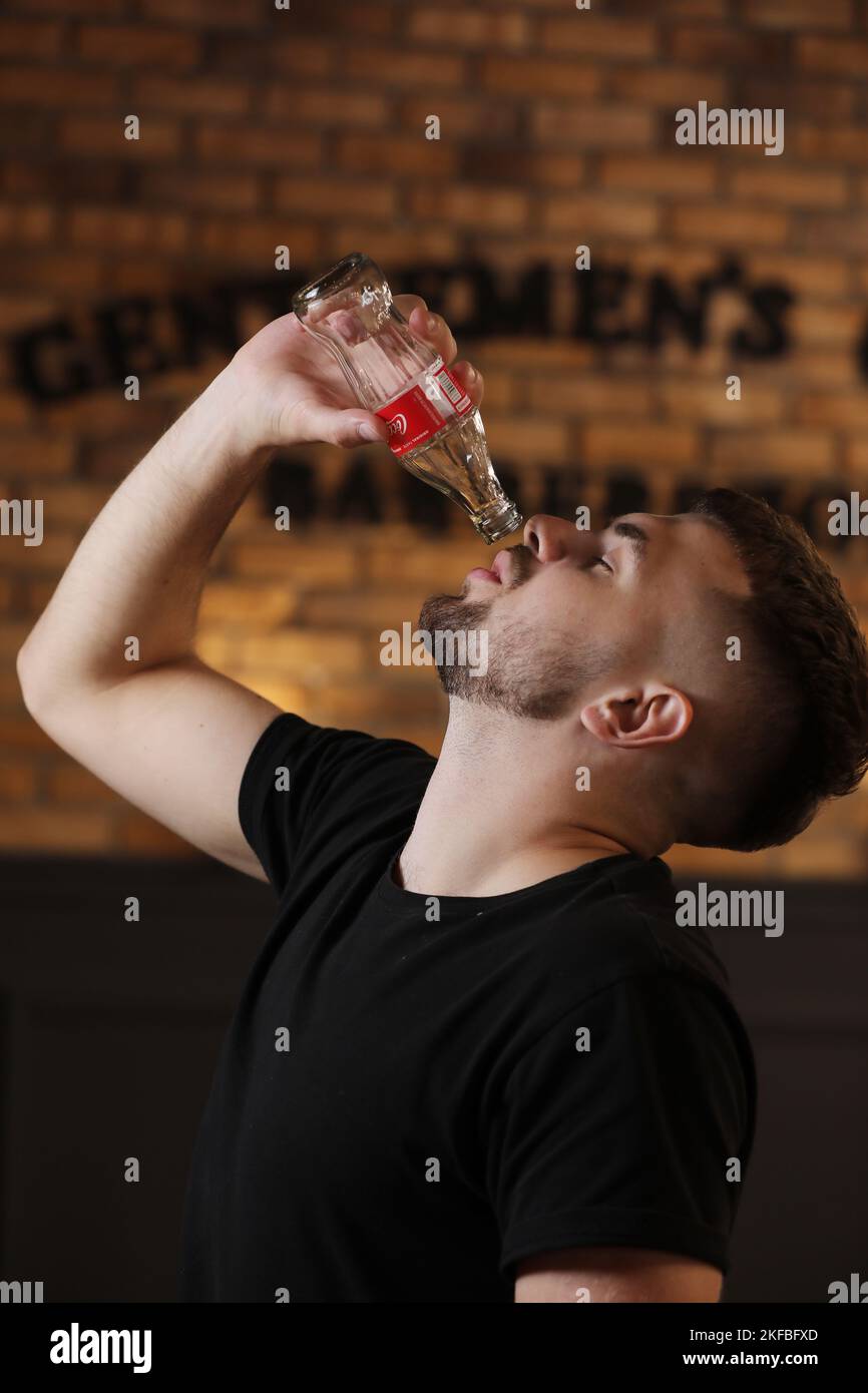 RIVNE, UKRAINE JUNE 26 2020: young bearded man drinking coca cola from ...