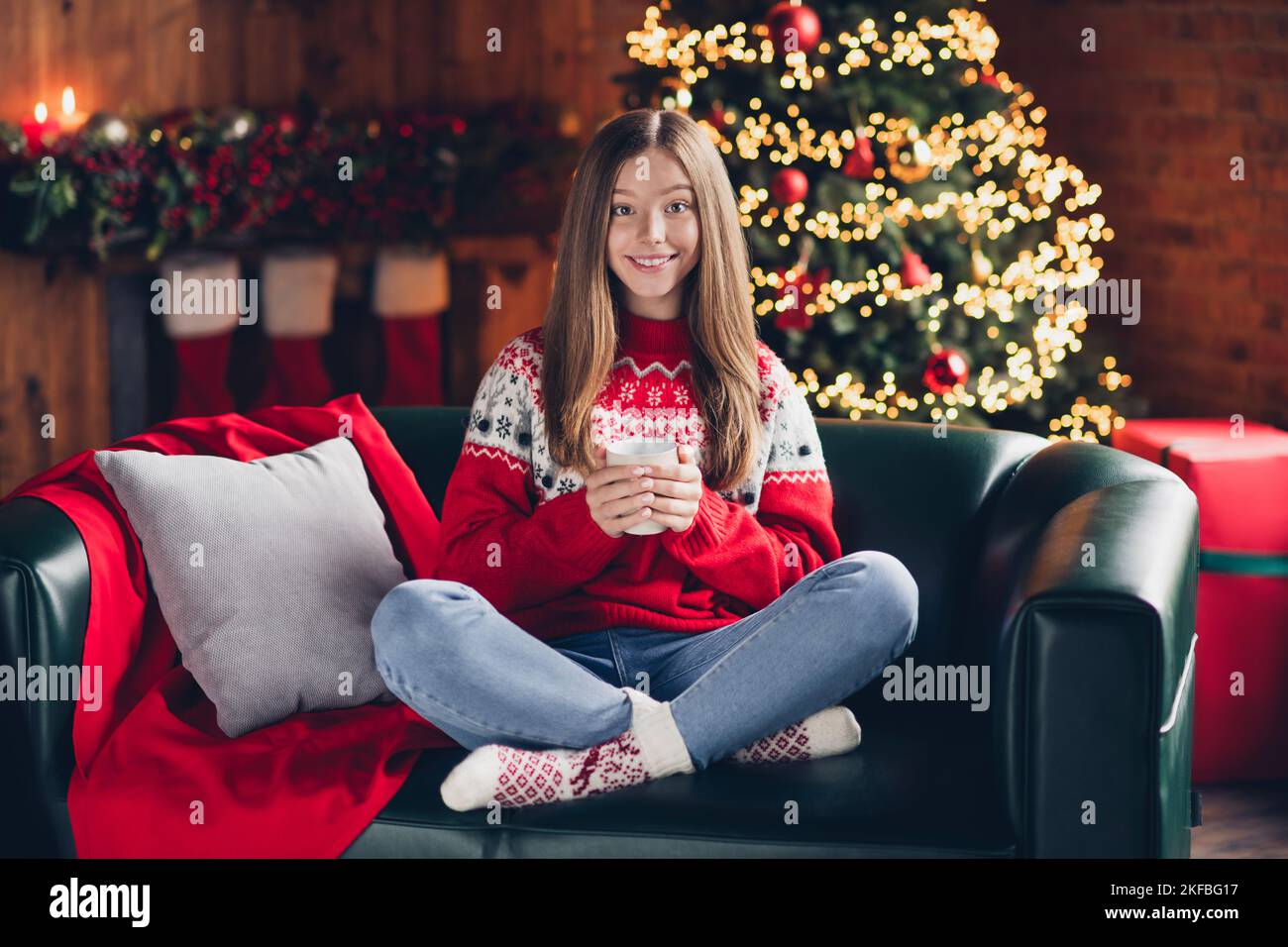 Full size photo of adorable positive girl sit couch arms hold hot ...