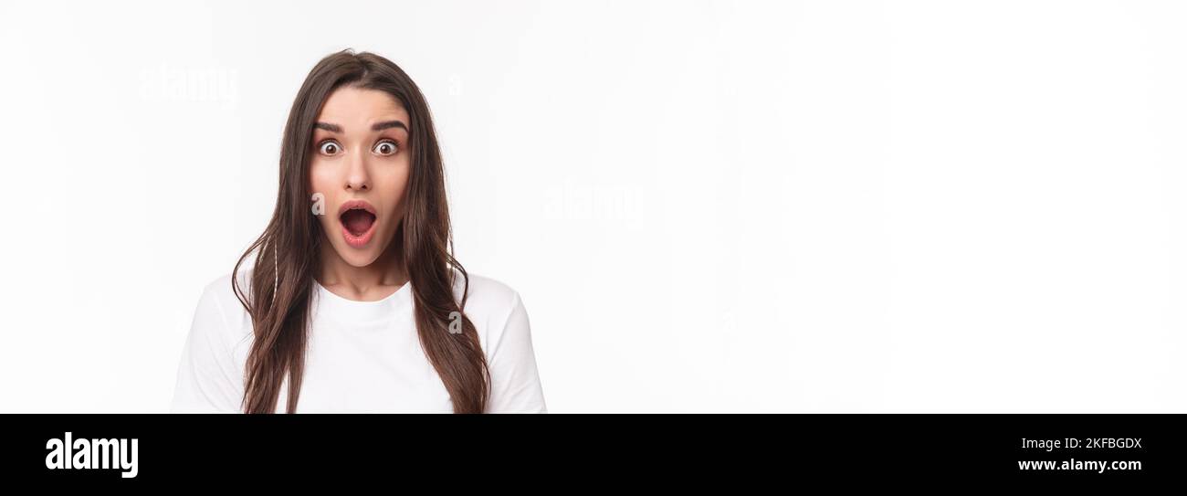 Close-up portrait of surprised and startled young brunette female drop ...