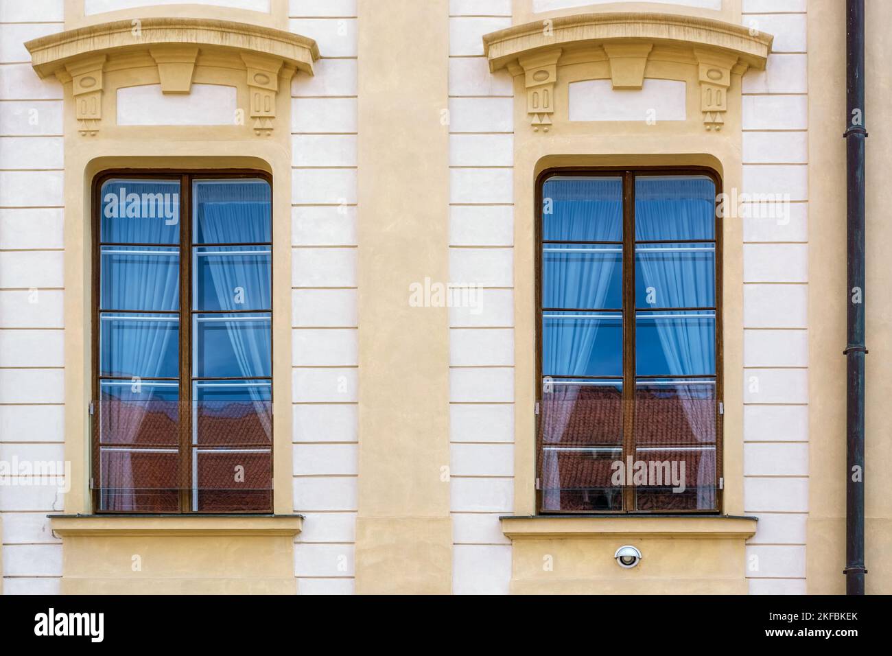 Two rectangular windows with a visor on the background of a yellow wall ...