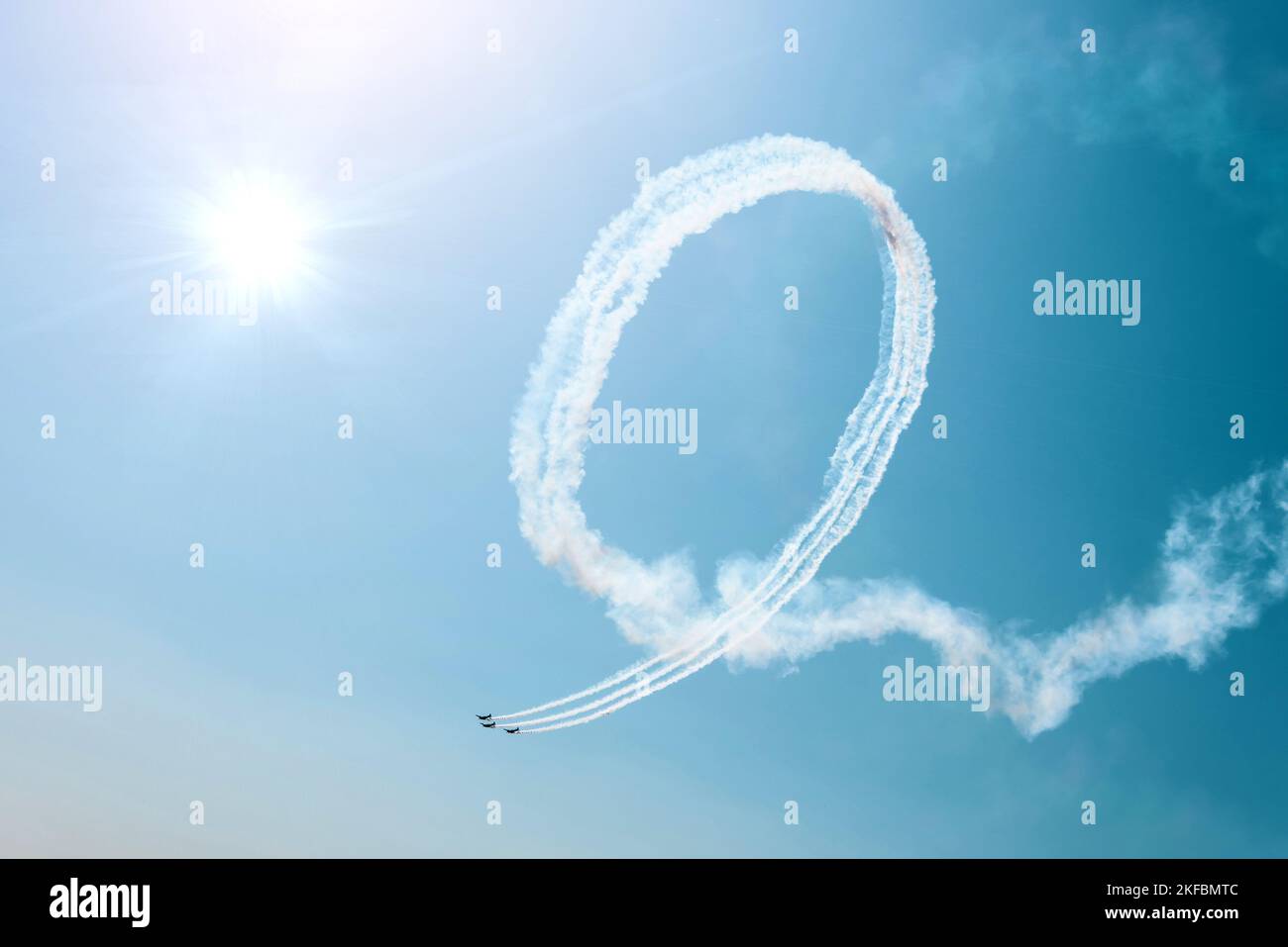 Three light-engine aircraft perform aerobatics. The bright sun ...