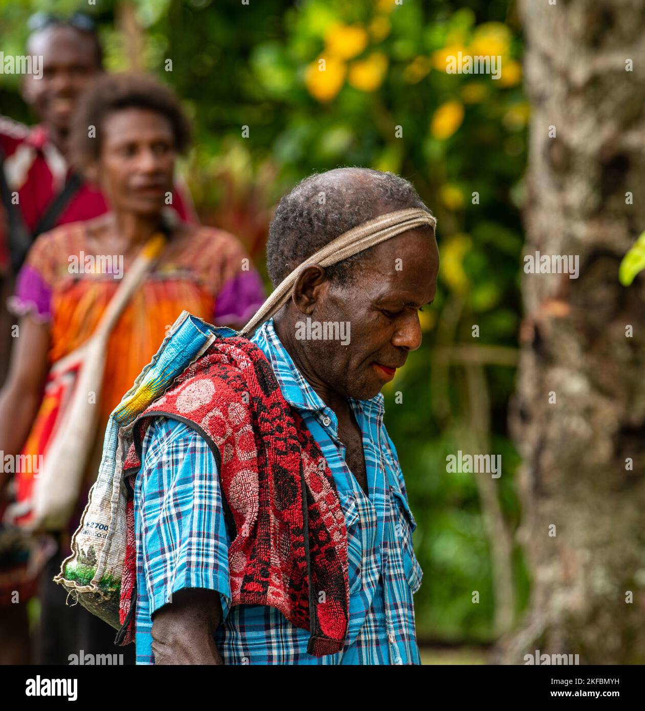 A villager in the East Sepik Province wears a traditional billum bag ...