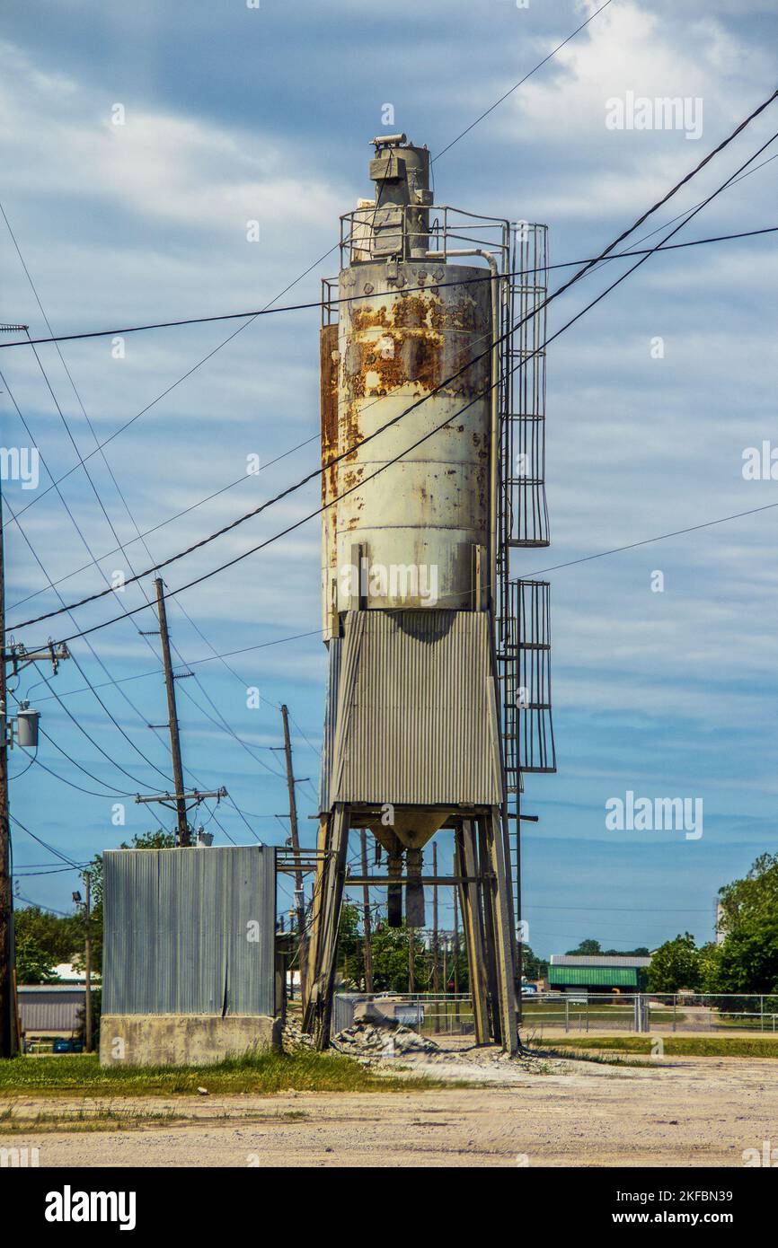 Old grungy rusty Silo for Concrete Batching Plant standing against blue ...