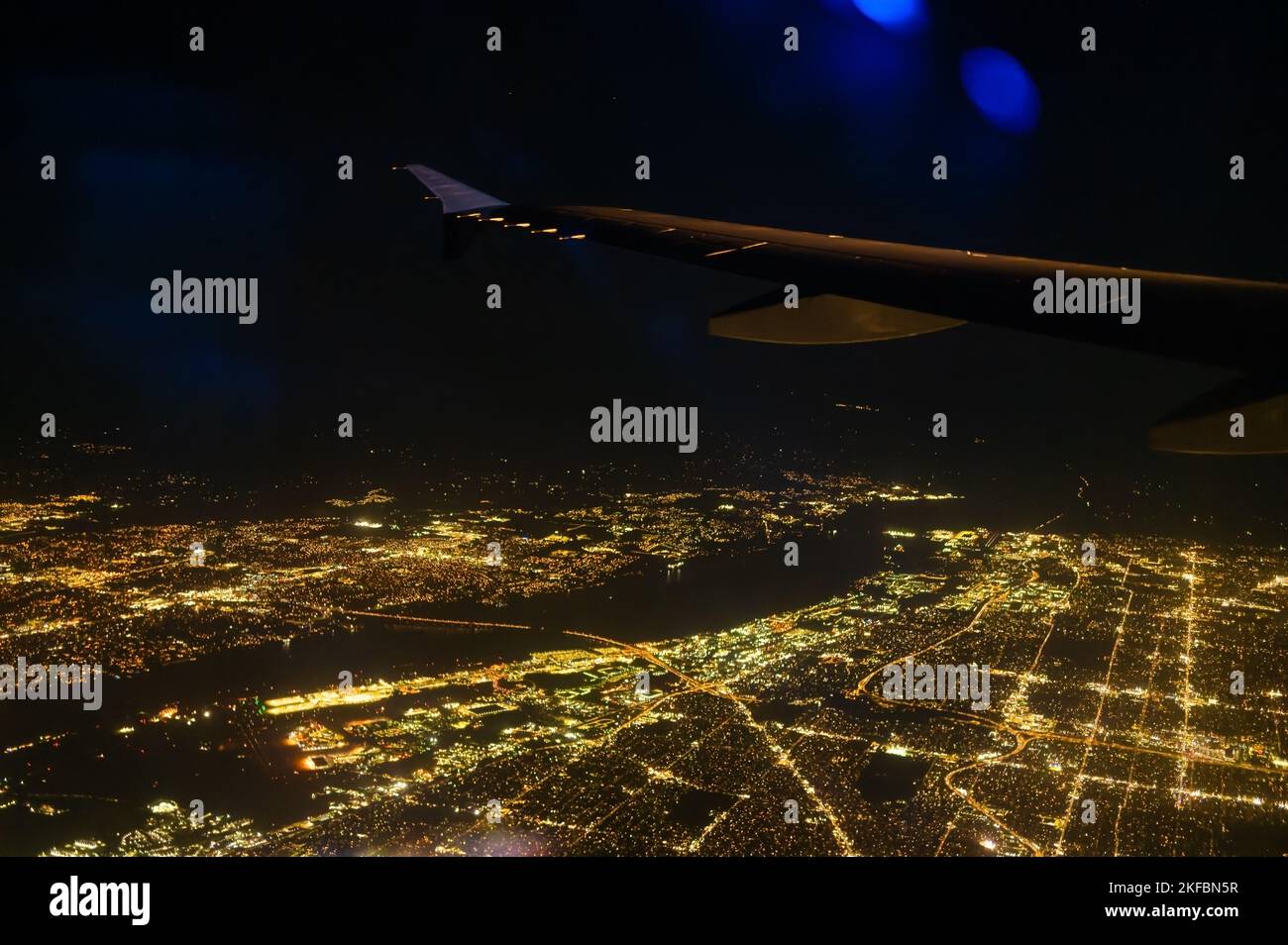 Airplane in the night dark blue sky. View of the city at night ...